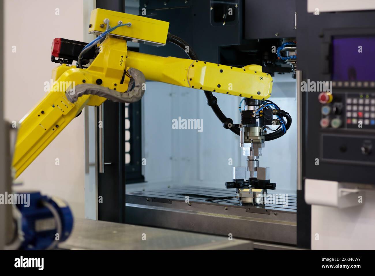 Collaborative robot loading workpieces into CNC machining center. Robotic work cell. Selective ...