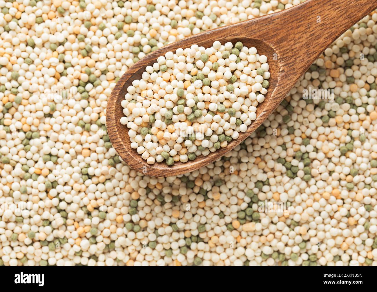 Assorted mix of raw healthy dry couscous grain seeds on wooden spoon ...