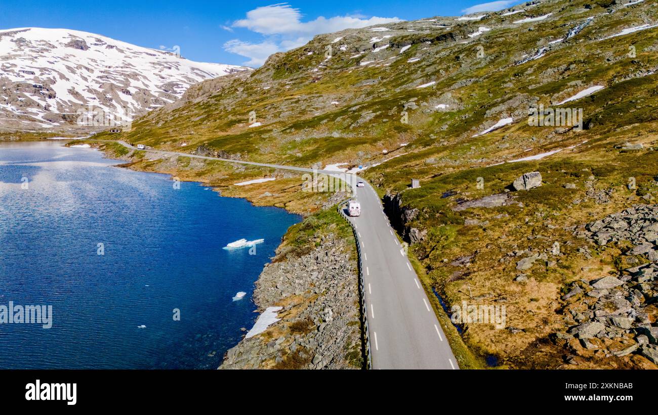 A winding road follows a scenic mountain pass in Norway, with a ...