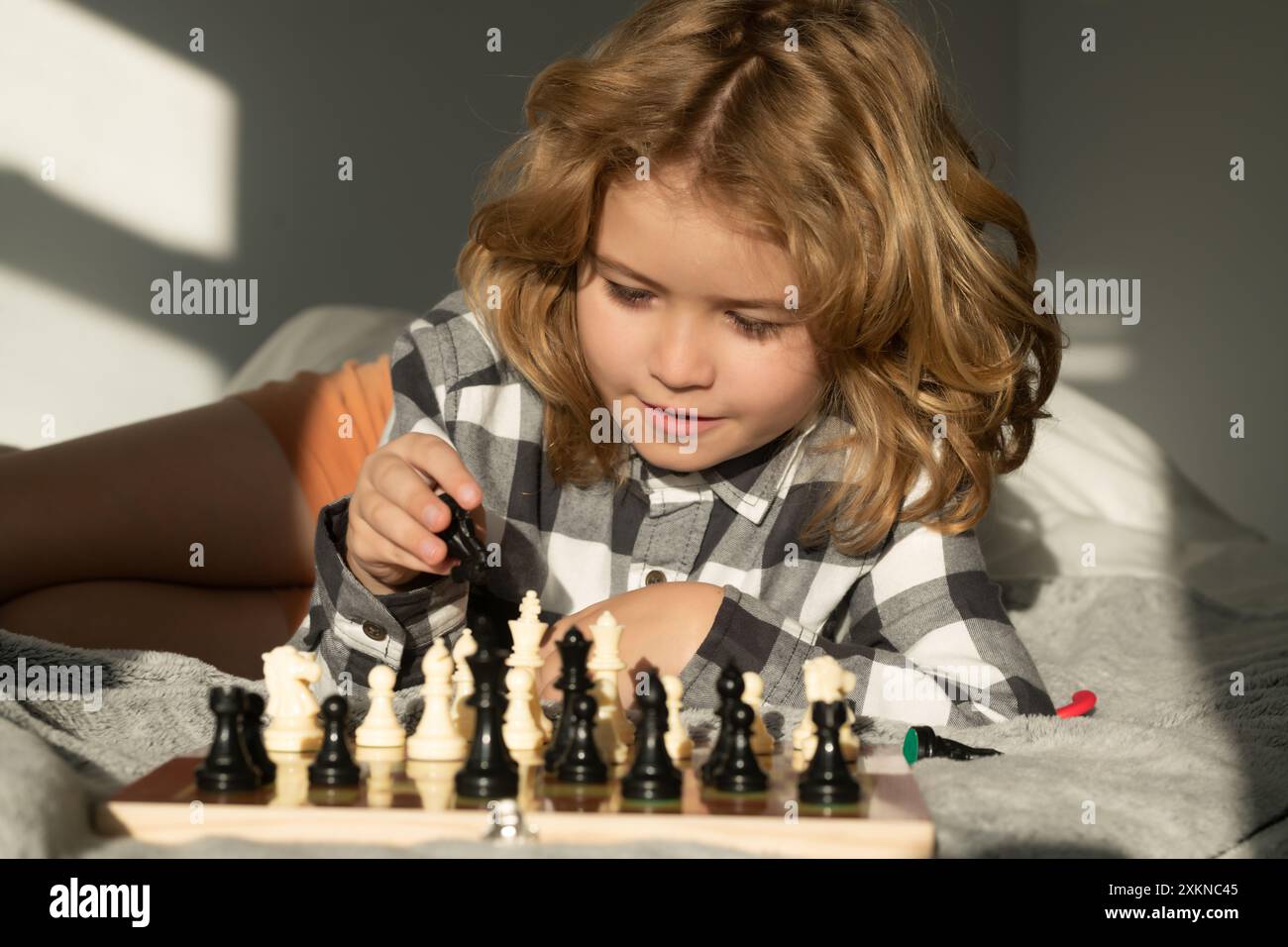 Cute boy are playing chess at home. Kid playing chess. Clever child ...