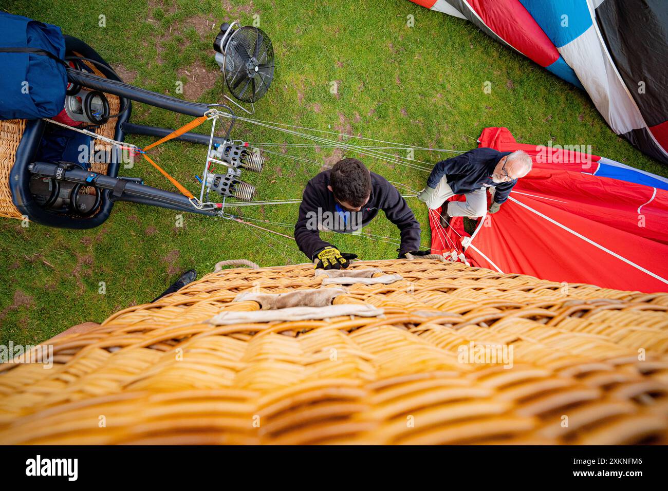 Hot air balloon crews push off a basket at the moment of lift off ...