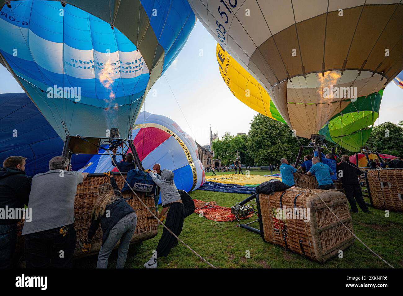 Hot air balloon pilots use burners to inflate the canopy as balloons prepare to launch during a ...