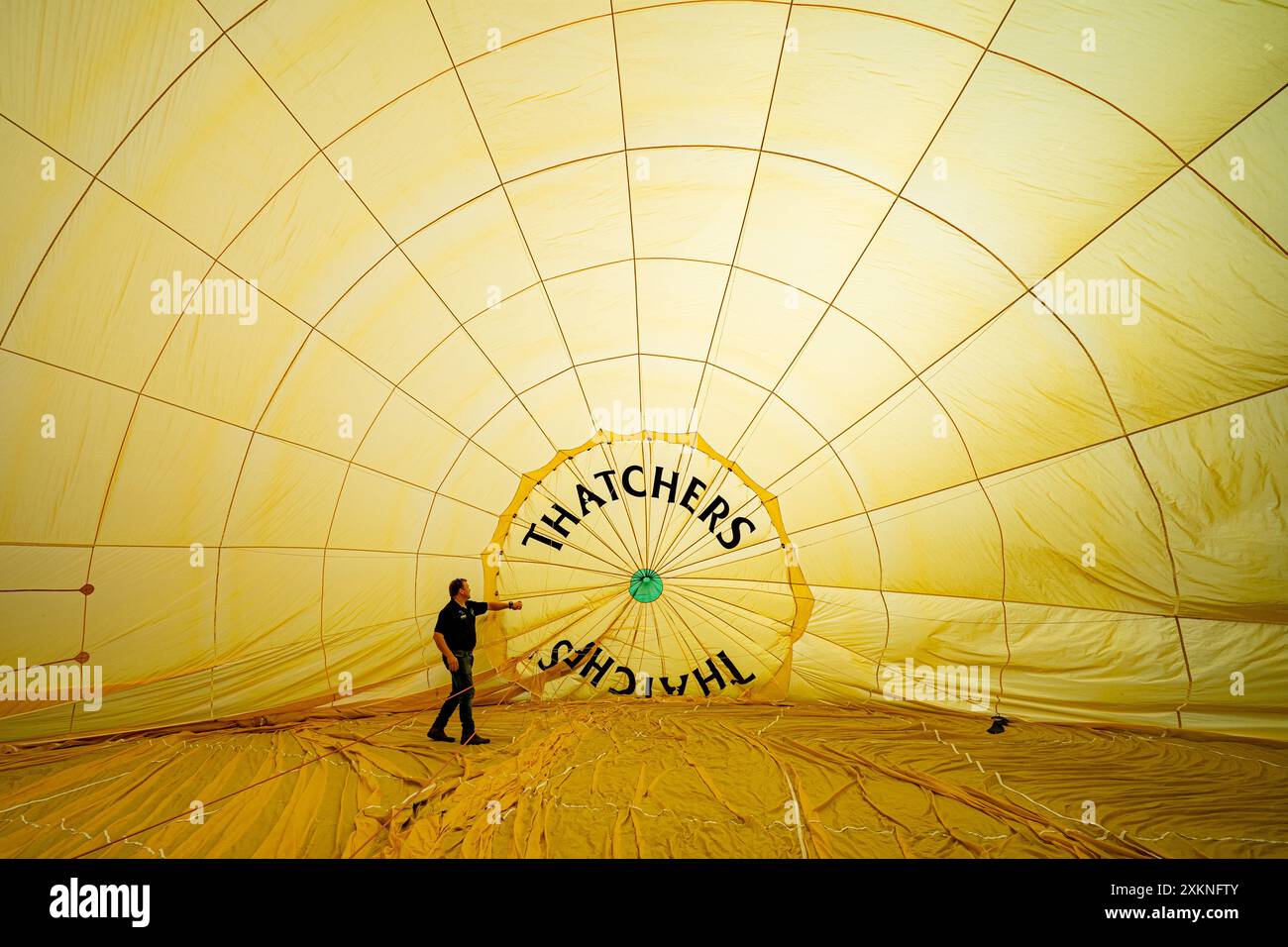 A hot air balloon pilot enters an inflated canopy to check the rigging ...