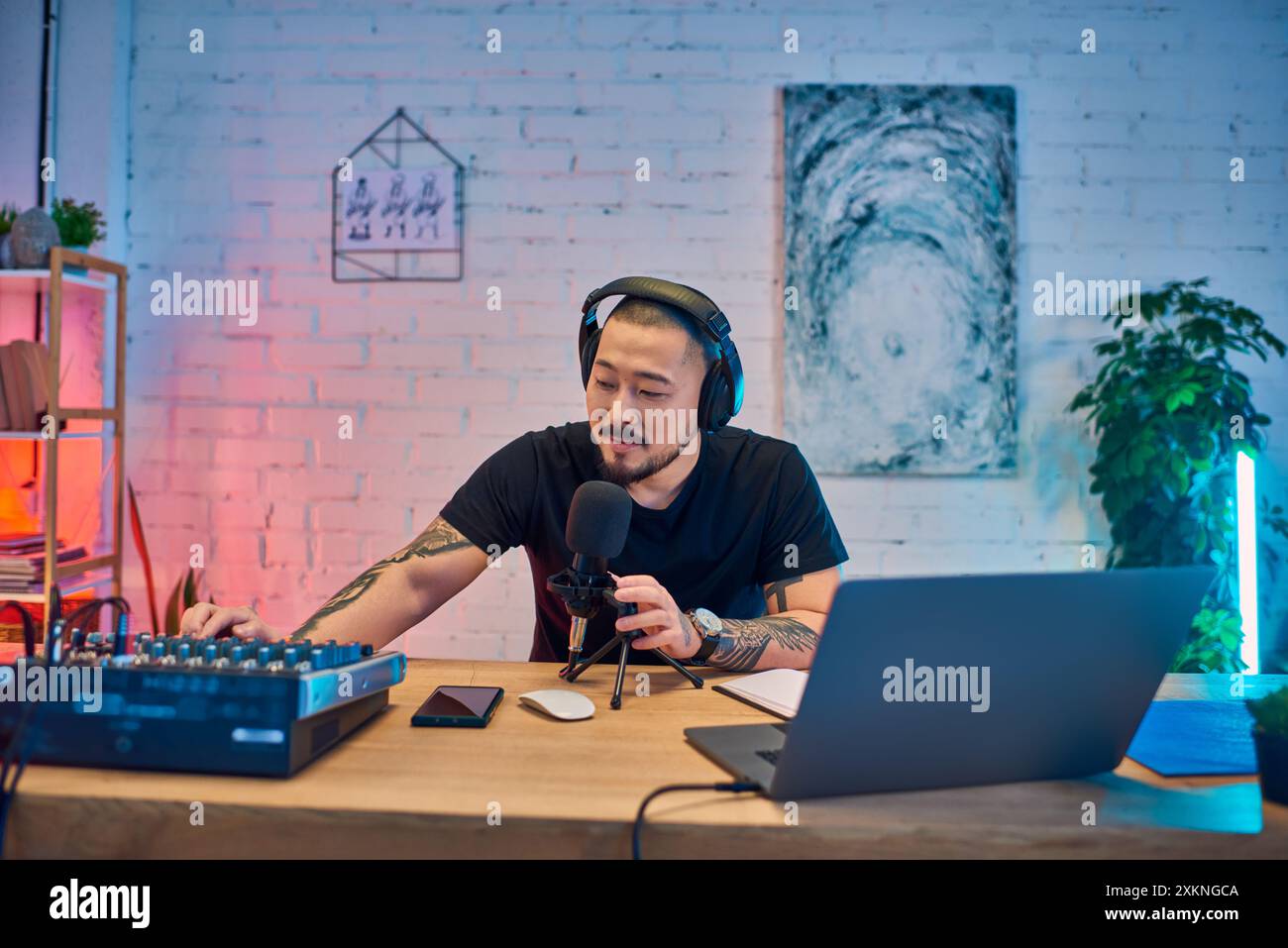 A handsome Asian man recording a podcast in his colorful home studio Stock Photo - Alamy