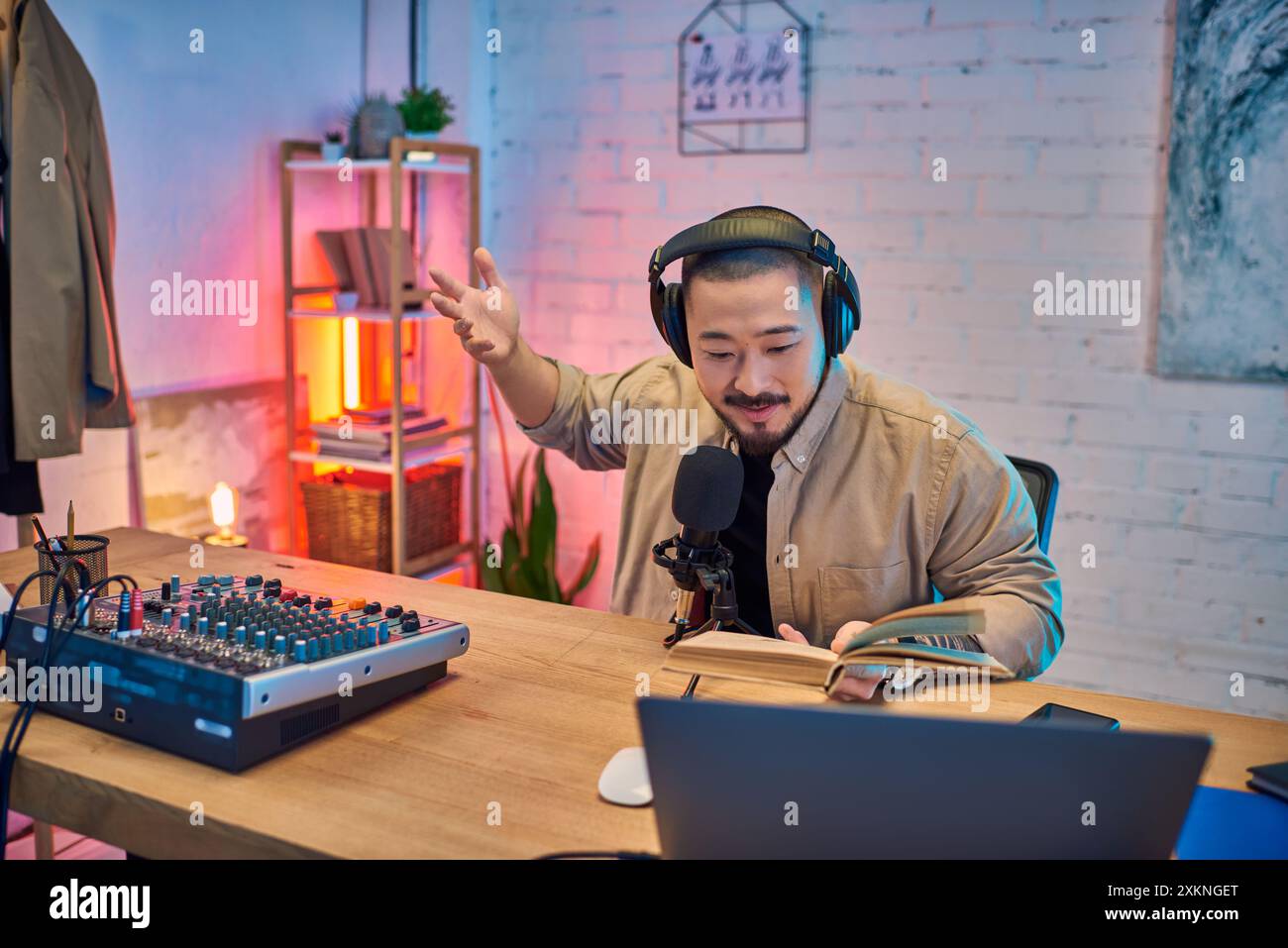 An Asian man records a podcast in his home studio, with a microphone ...