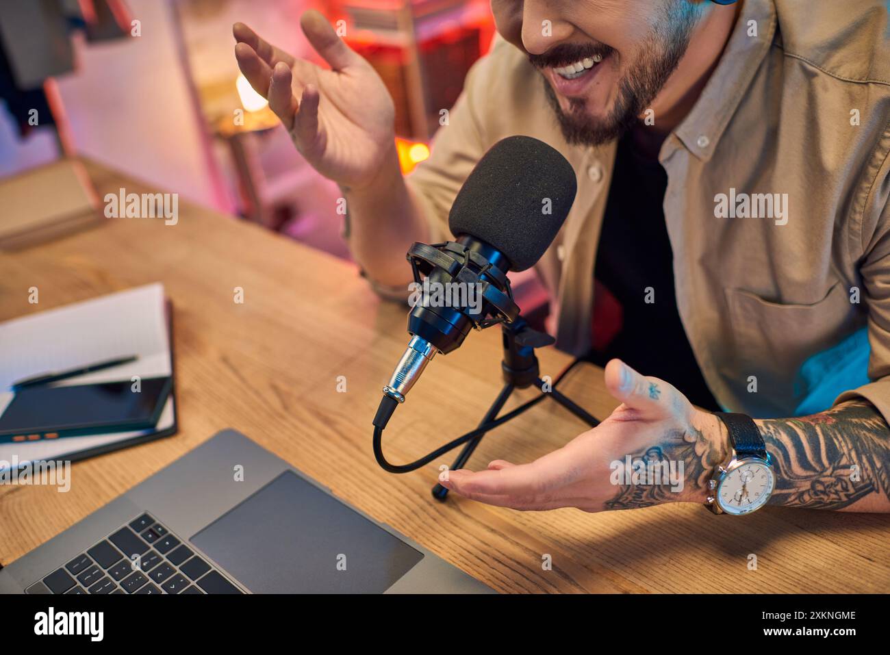 An Asian man records a podcast in a studio, speaking into a microphone ...