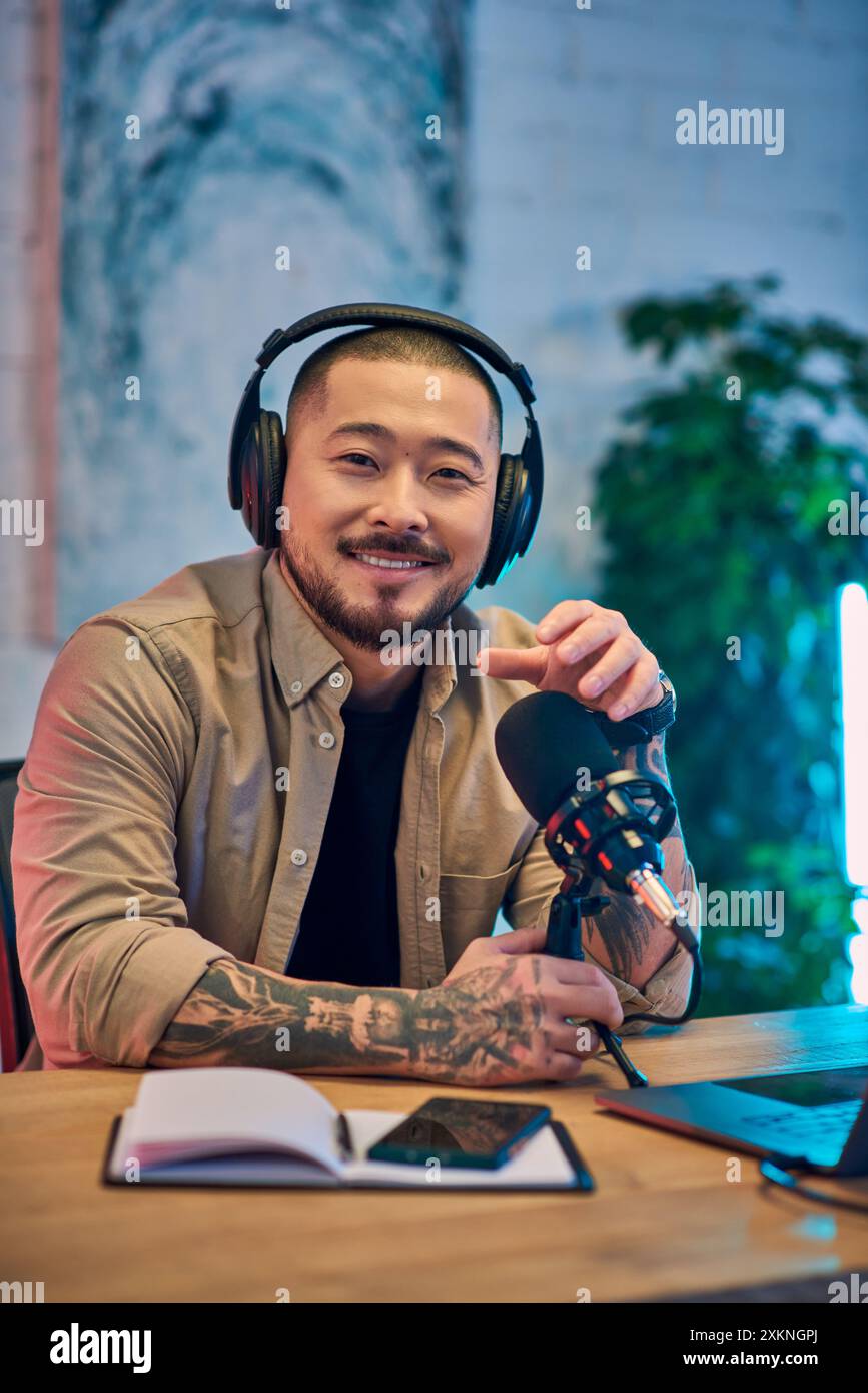 A handsome Asian man podcasting at his desk with headphones on Stock ...