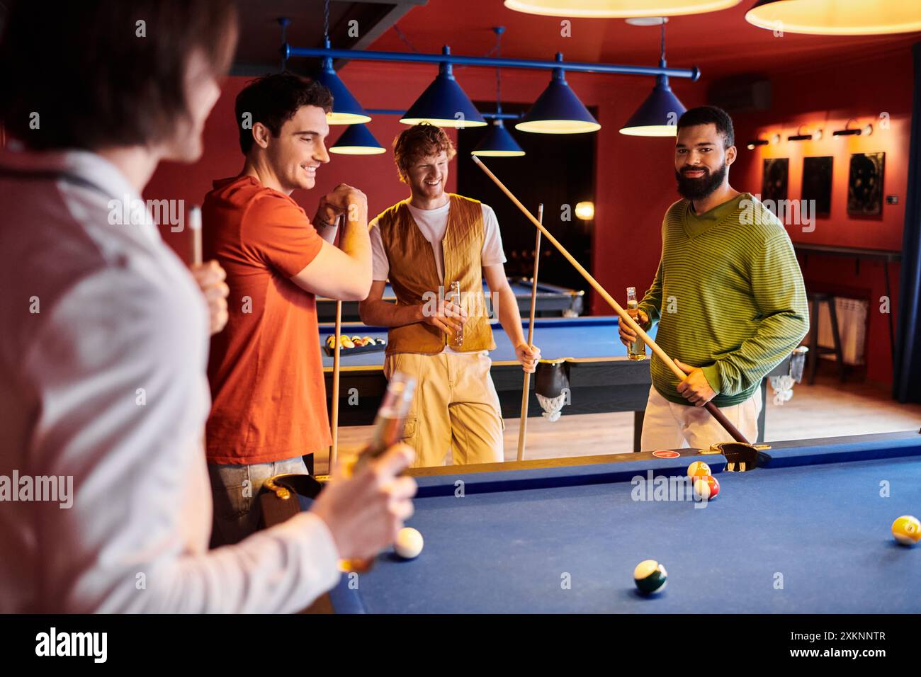 Friends enjoy a casual game of billiards in a stylish lounge Stock ...