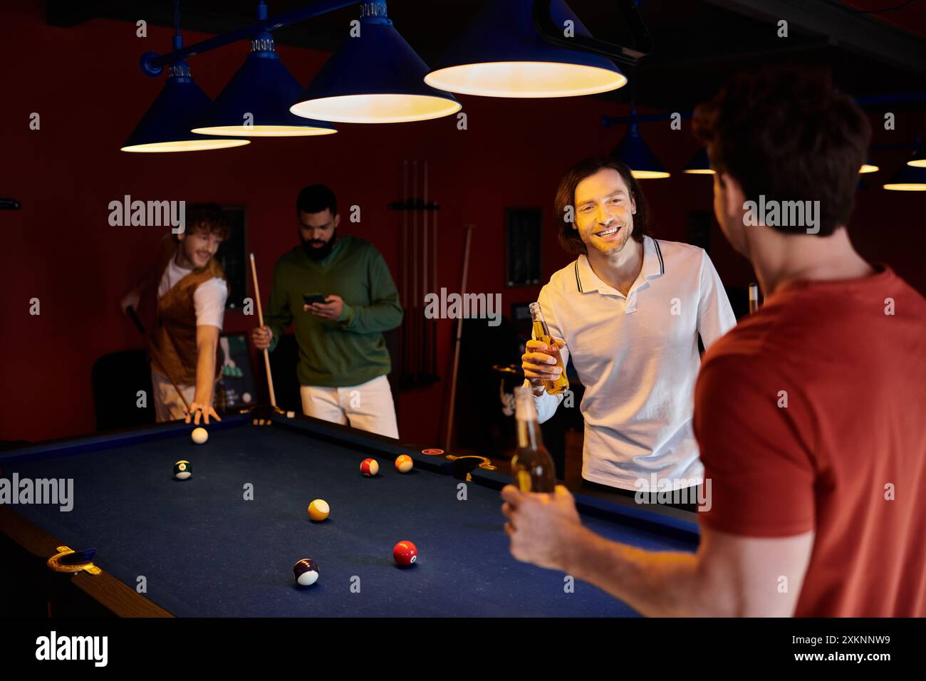 A group of friends play billiards in a dimly lit room, enjoying drinks ...