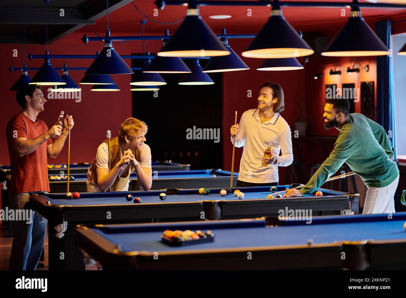 Friends in casual attire gather around a pool table for a friendly game ...