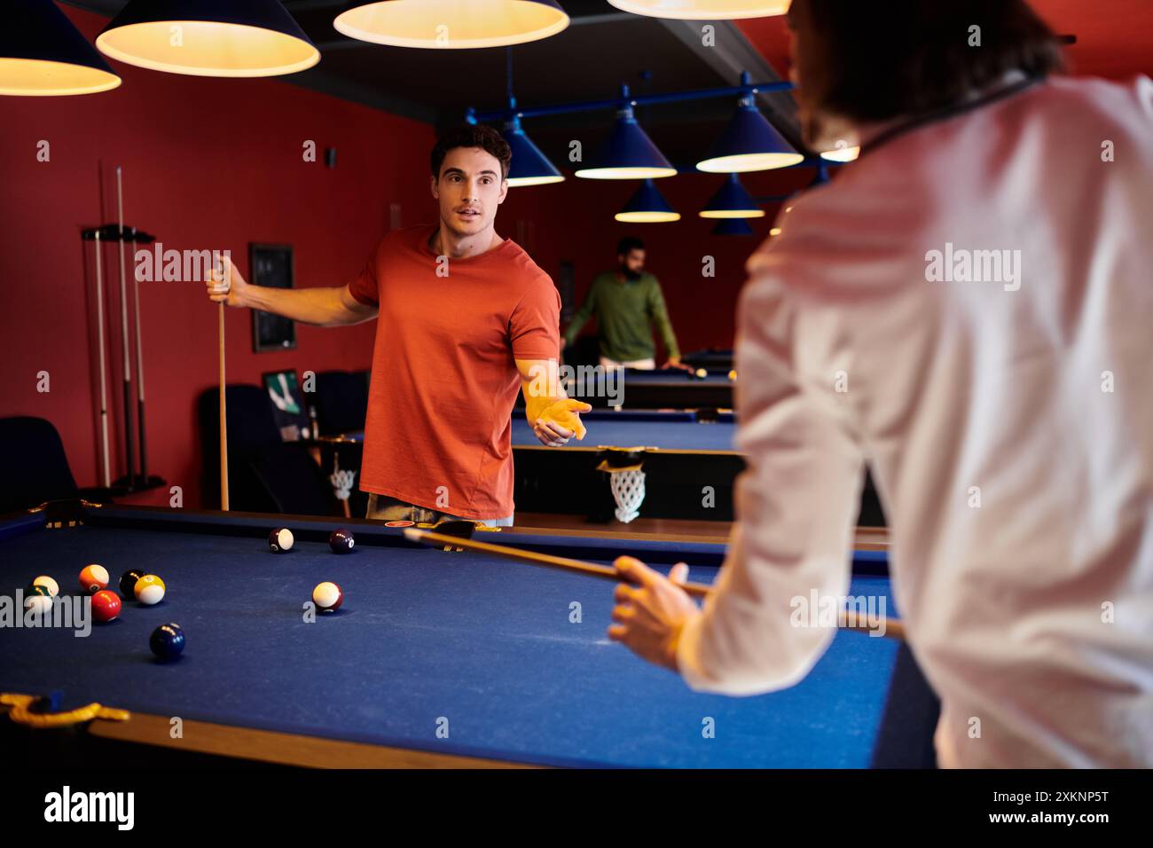 Friends play billiards in a brightly lit pool hall Stock Photo - Alamy