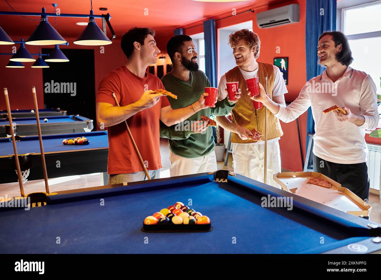 Friends enjoy a casual game of billiards and pizza Stock Photo - Alamy