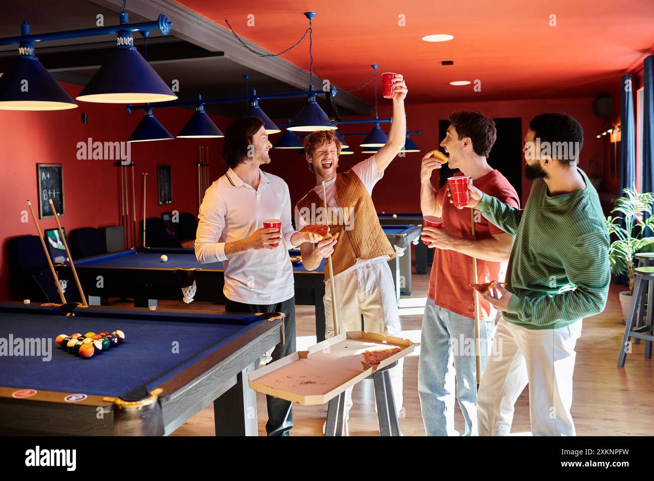Friends casually dressed, enjoying a game of billiards in a brightly ...