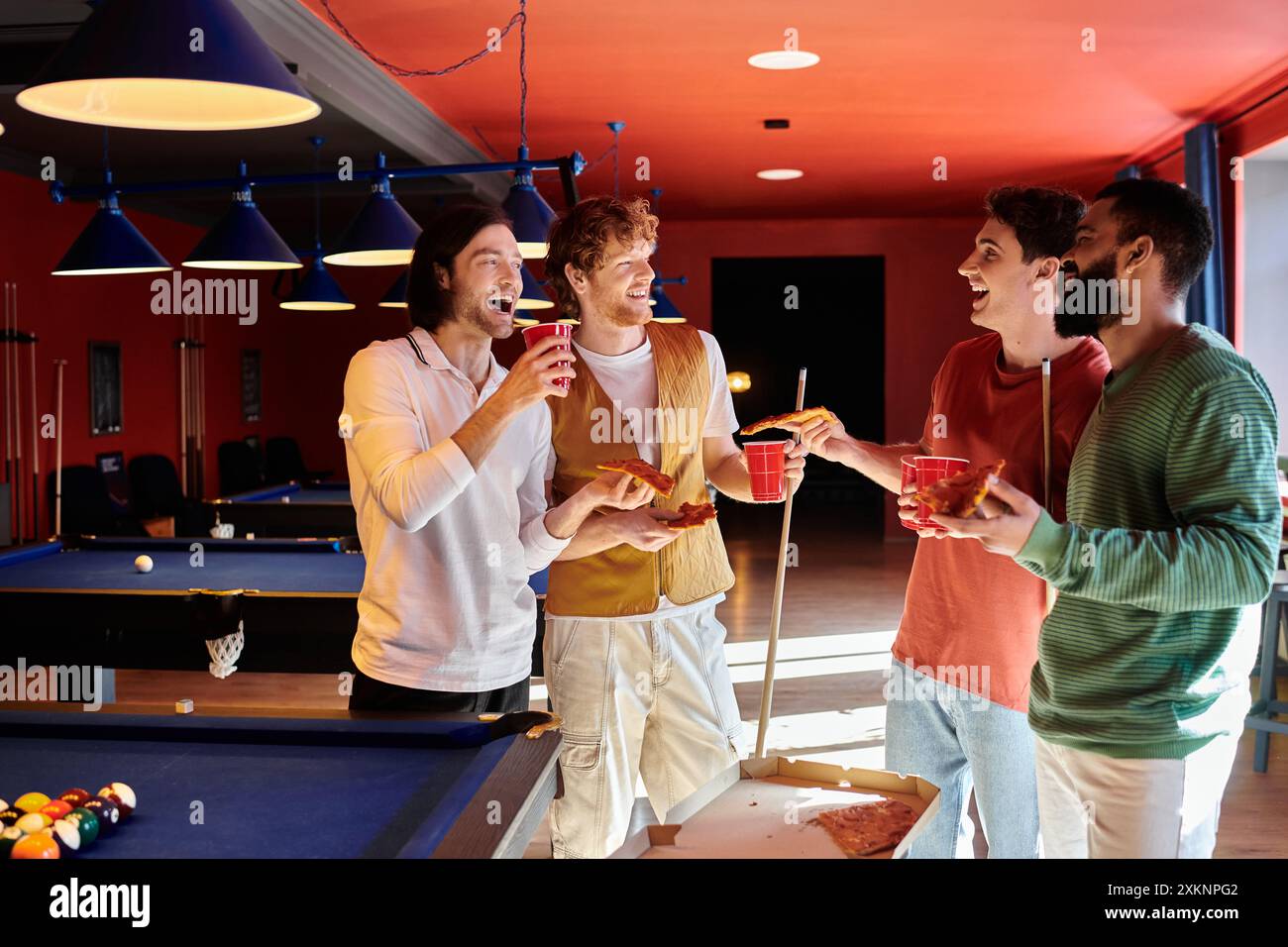 Friends enjoy a casual night out playing billiards and eating pizza ...