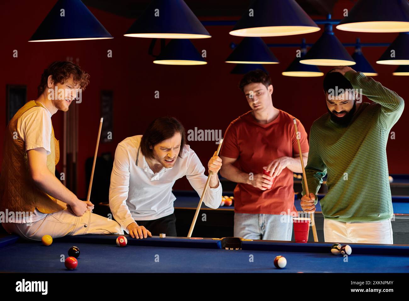 Friends are gathered around a pool table, enjoying a friendly game of ...
