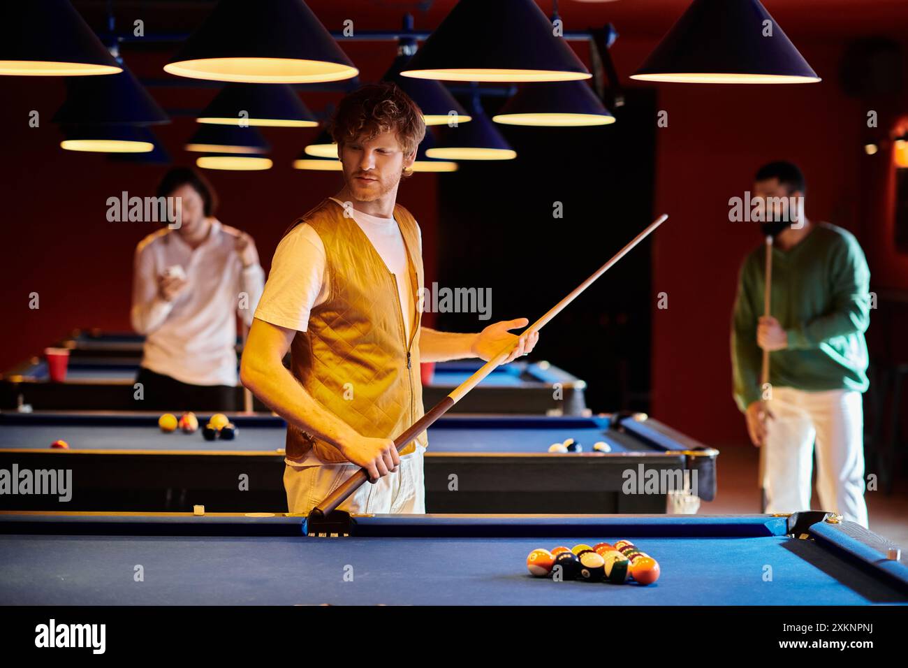 A group of friends enjoys a friendly game of billiards at an indoor ...