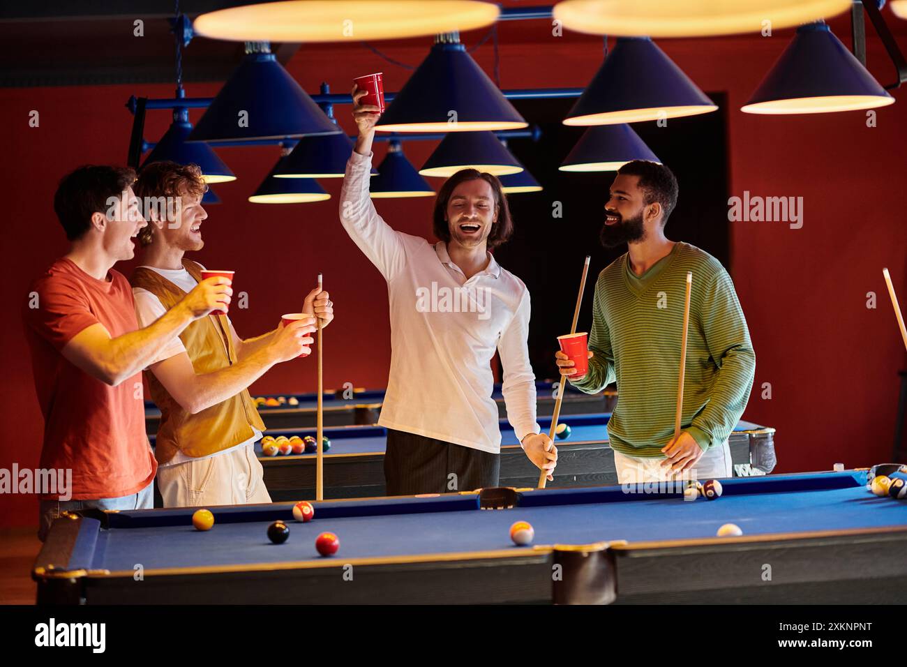 Friends celebrate a win during a casual billiard game, laughing and ...