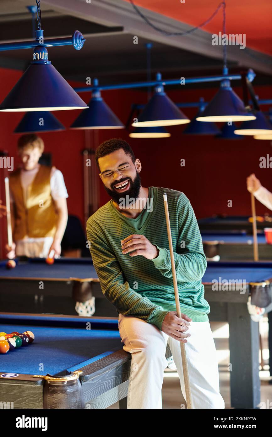 Friends play a casual game of billiards in a stylishly lit lounge Stock ...