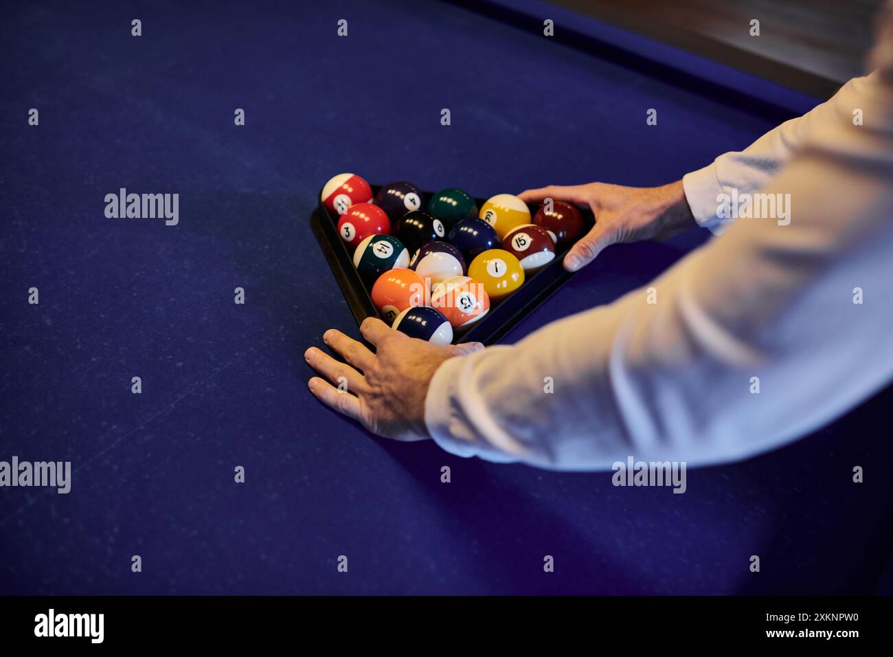 A player arranges the billiard balls in a triangle on the felt-covered ...