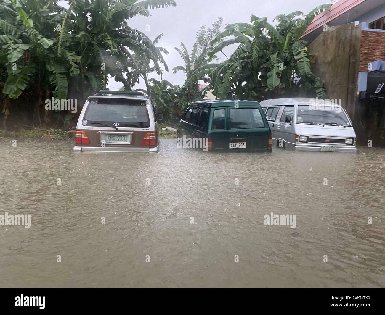 Manila, Philippines. 24th July, 2024. Cars stand in a flooded parking ...