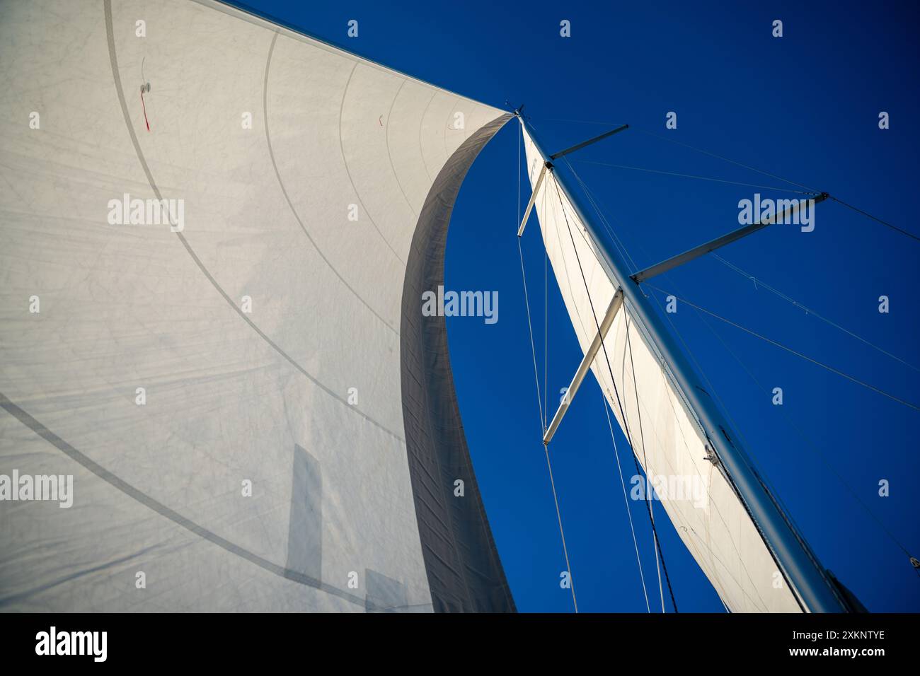 Sails of a sailing yacht in the wind sailing on the sea at sun light ...