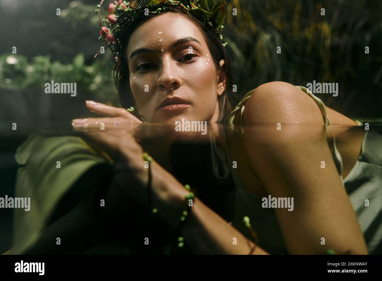 A woman wearing a floral crown poses in a swamp, her head partially ...