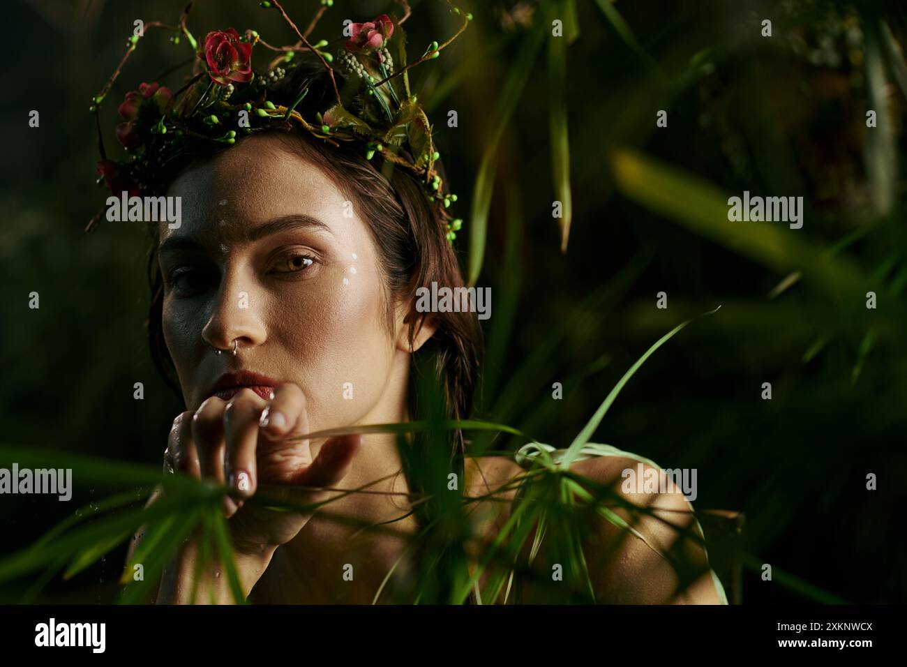 A woman in a floral crown poses amidst lush greenery near a swamp Stock ...