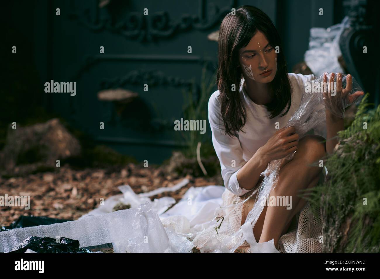 A woman in aesthetic clothing poses amidst a swamp filled with plastic ...
