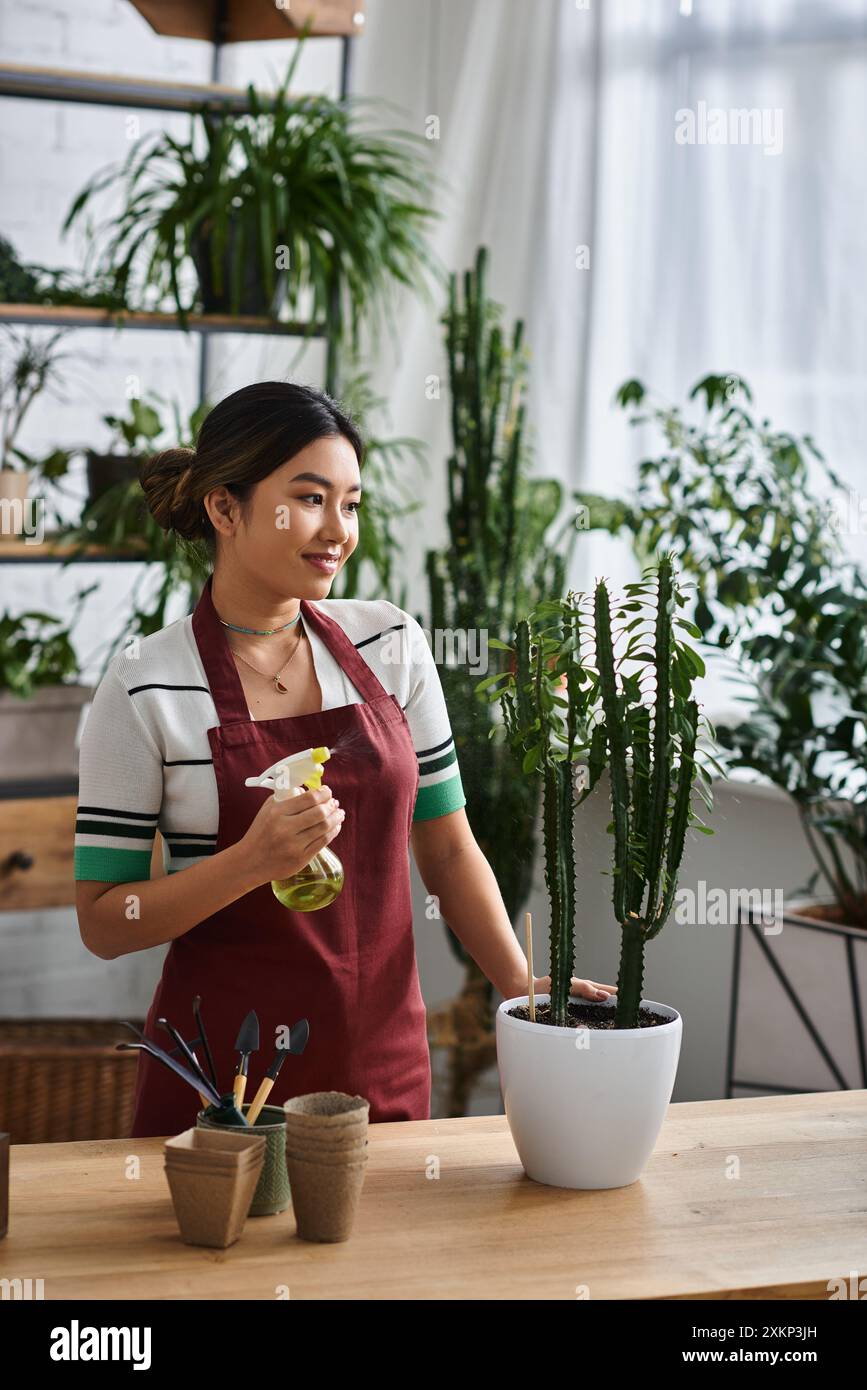 A young Asian woman in an apron, the owner of a plant store, is ...