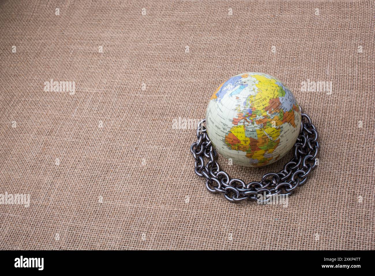 Chain around globe placed on canvas background Stock Photo - Alamy