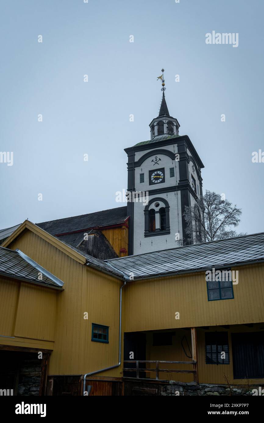 The Roros Church stands amidst of traditional Scandinavian wooden homes ...