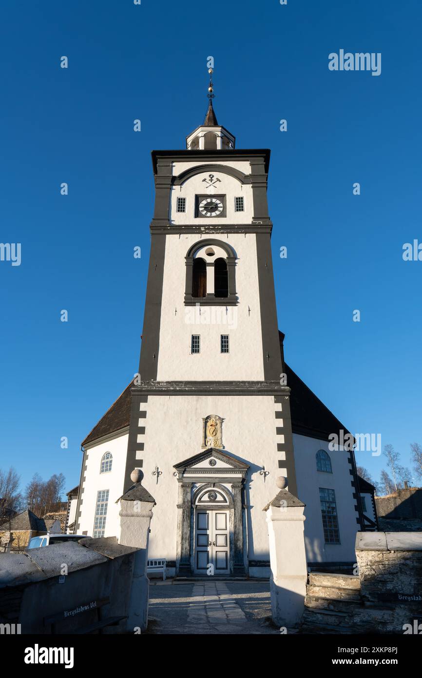 The Roros Church stands amidst of traditional Scandinavian wooden homes ...