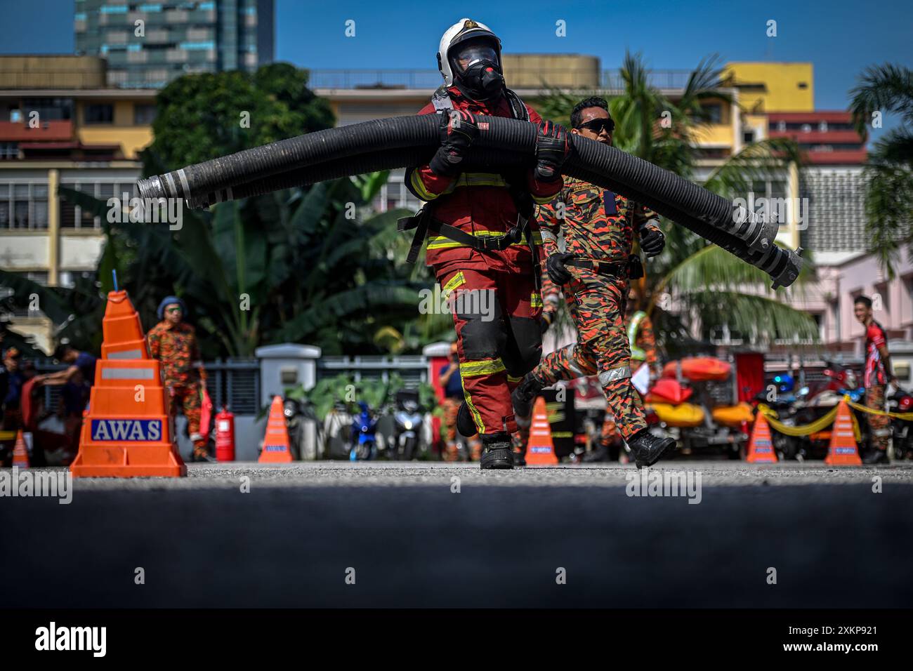 A firefighter carrying hoses runs during a firefighting skills ...