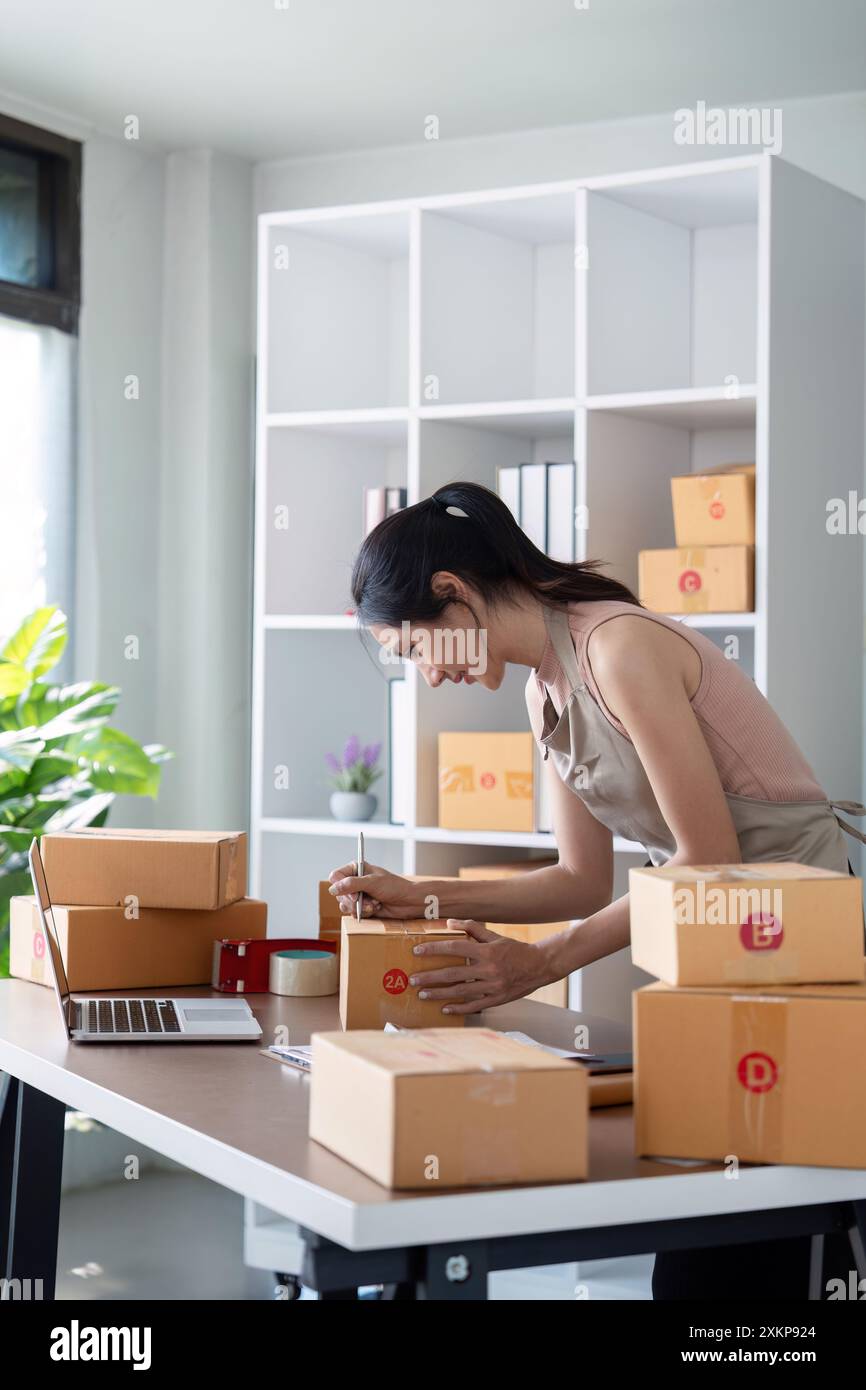 Young Woman Packing Boxes for Shipping in Modern Home Office with ...