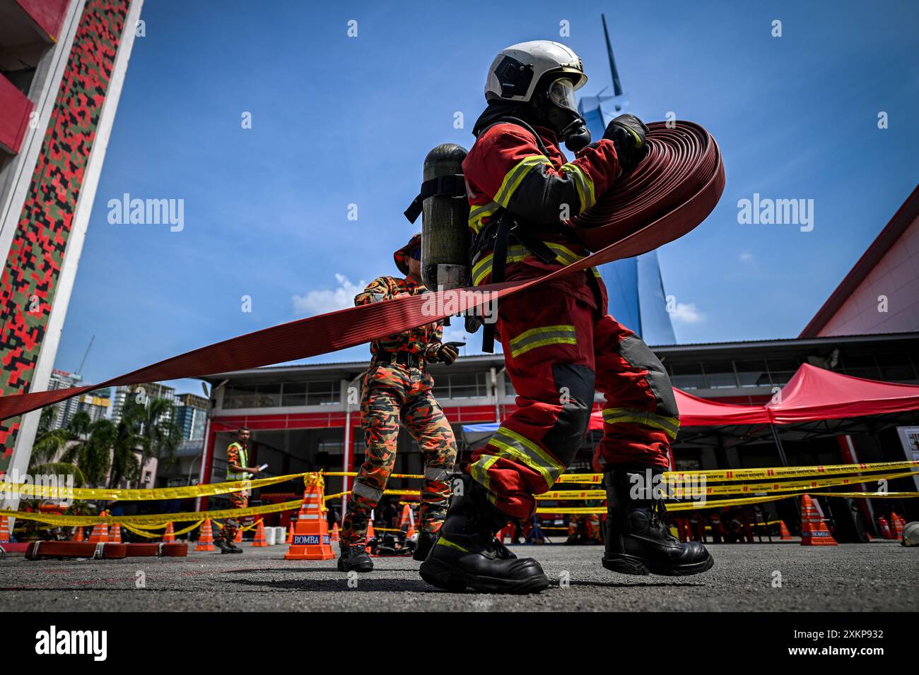 A firefighter pulls a tube in full uniform during a firefighting skills ...