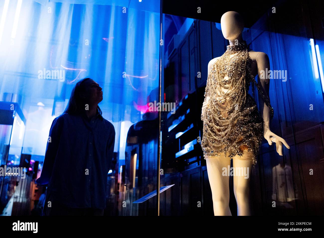 A gallery assistant look at a costume worn by Taylor Swift to announce ...