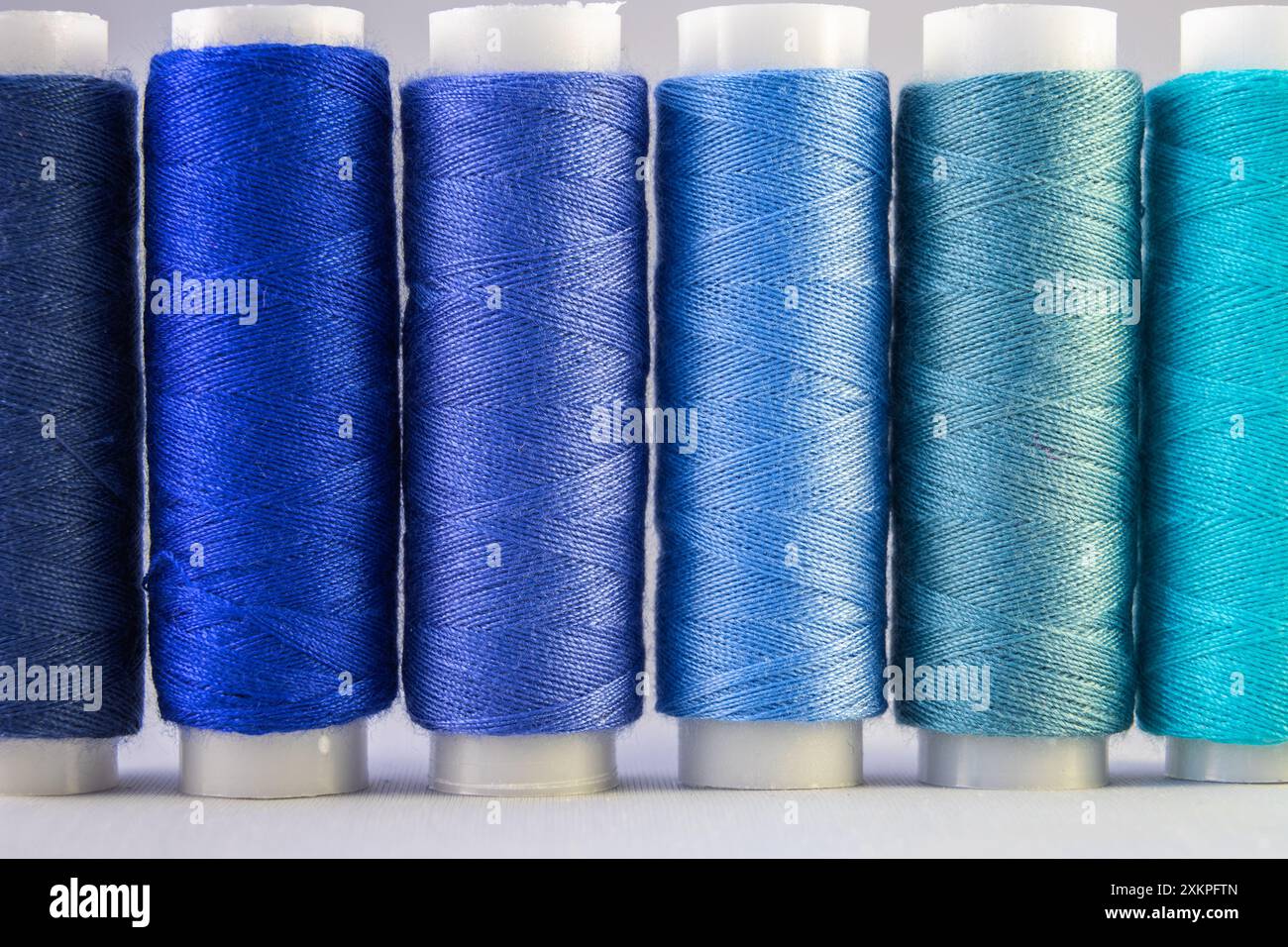 An assortment of blue sewing threads on white background Stock Photo ...