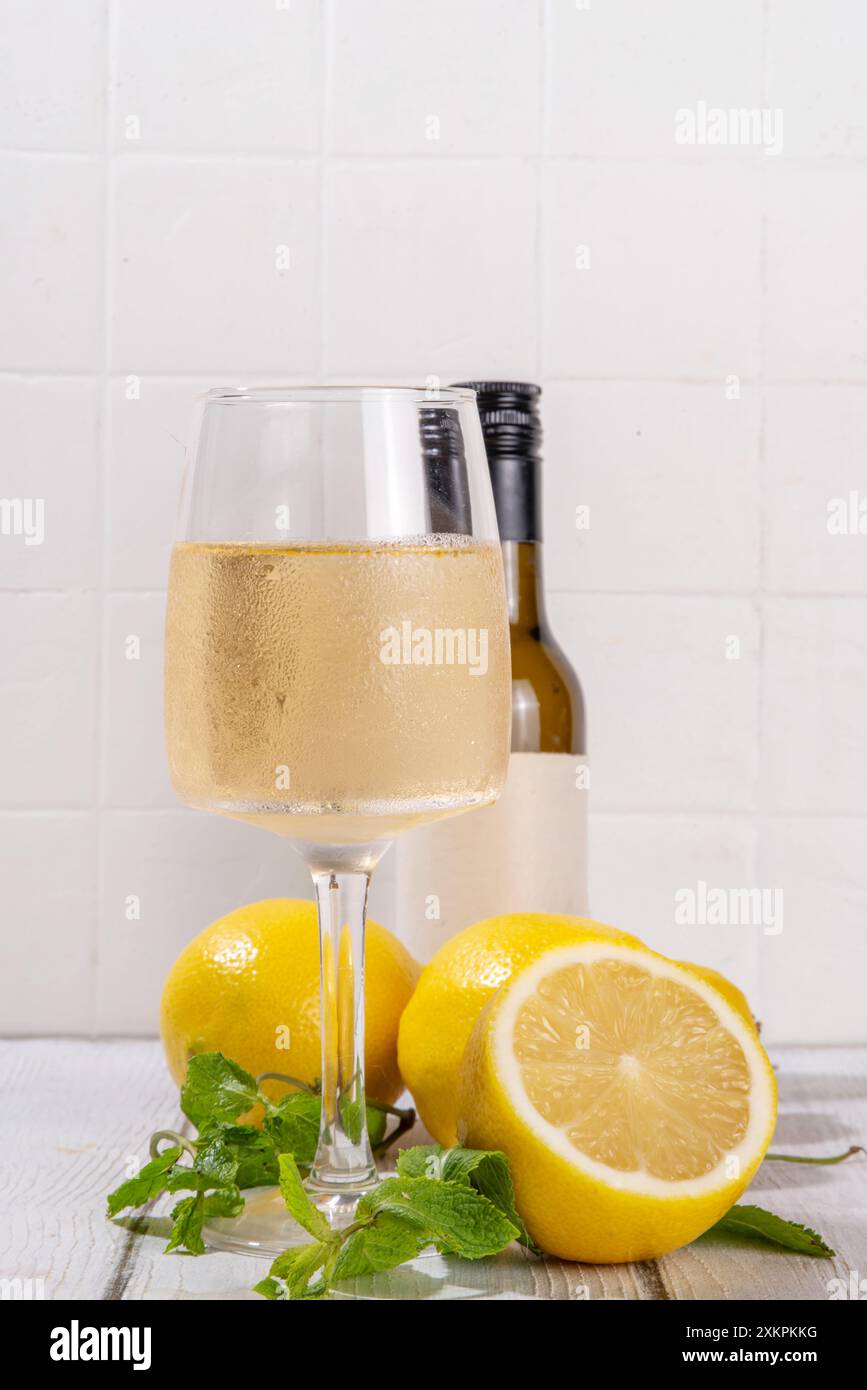 Lemon Wine glass and bottle with sliced and whole lemons and mint ...