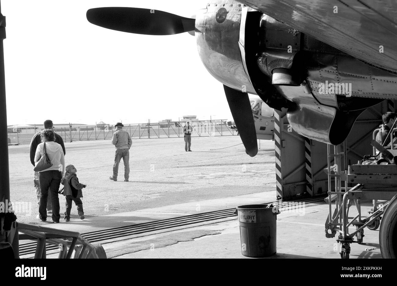 Small Caucasian girl with family turning to look back at plane in ...