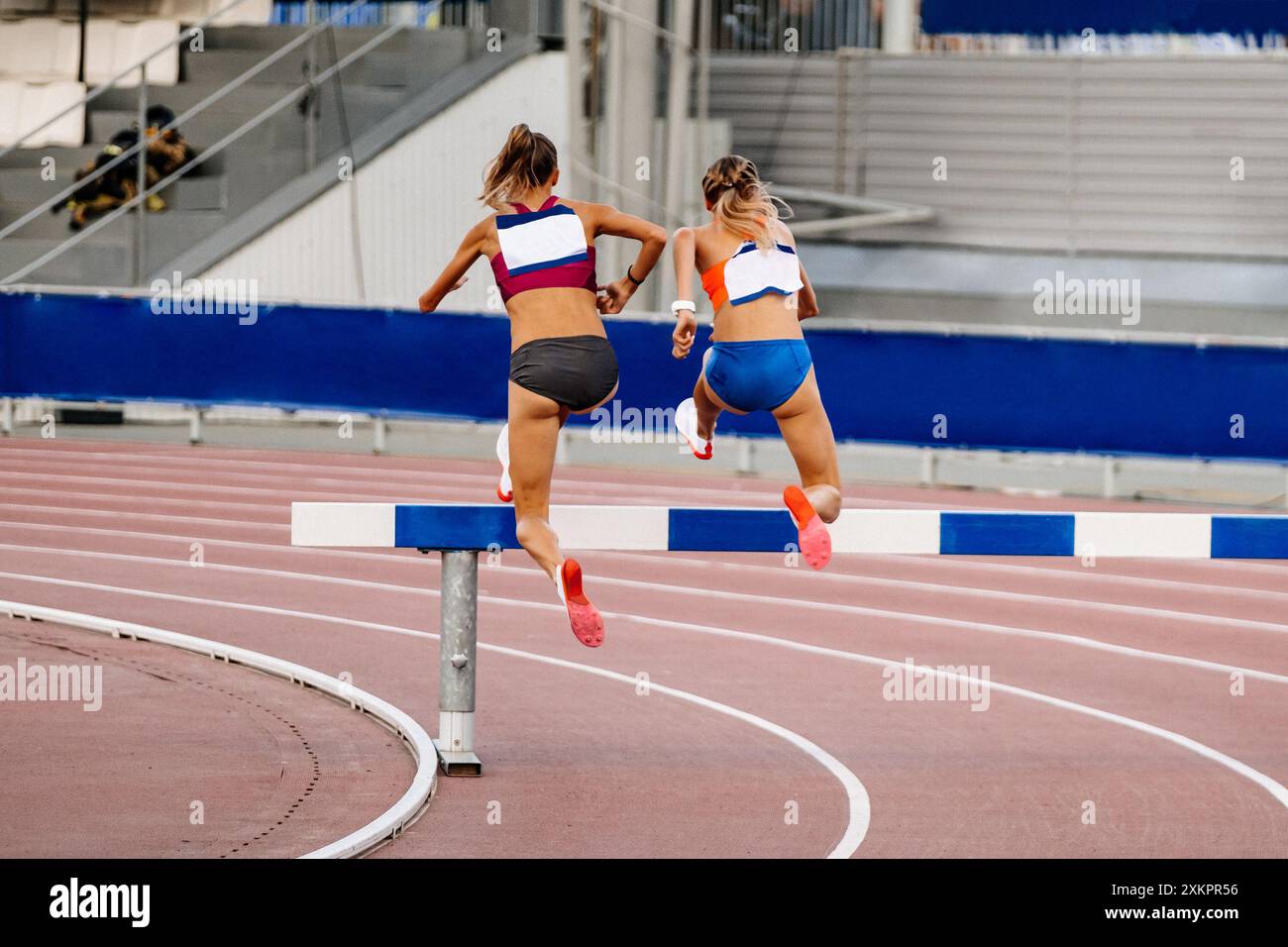 3000 metres steeplechase, two women synchronously overcome barrier ...