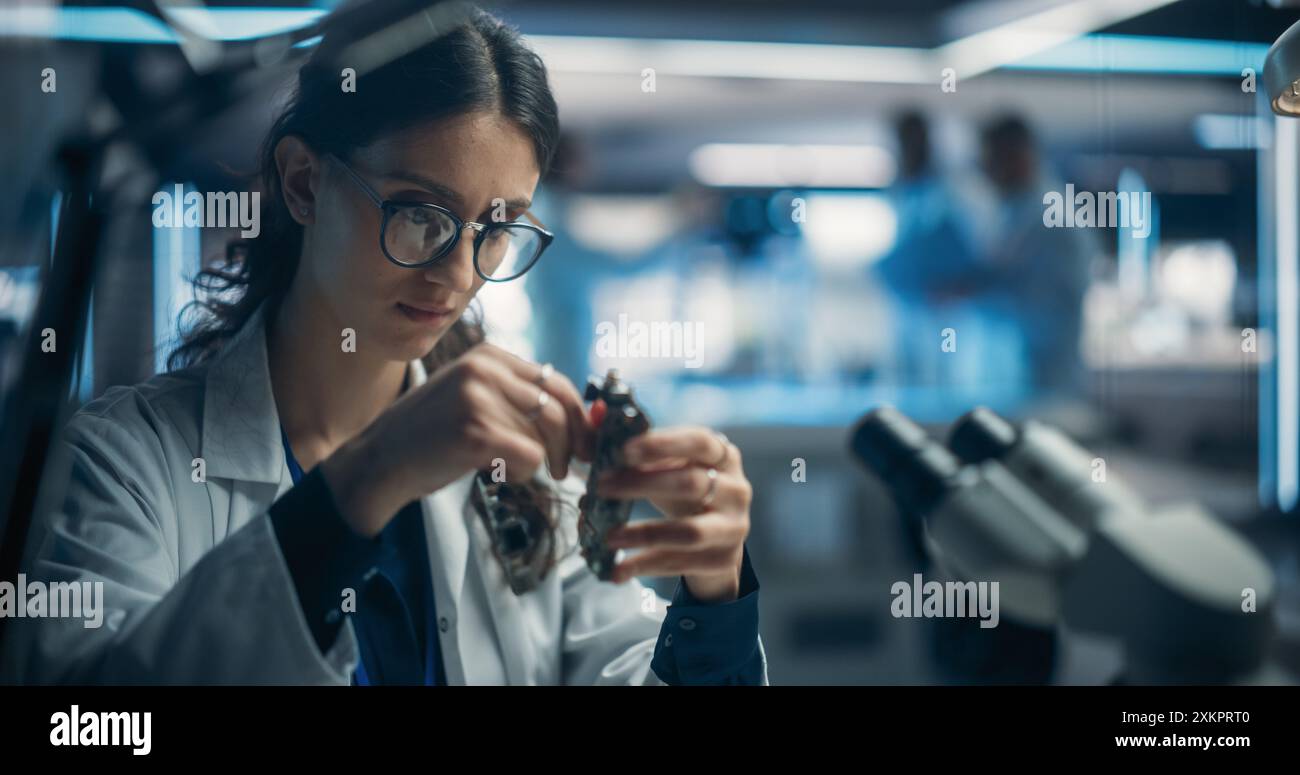 Focused Professional Female Engineer Working on Electronic Circuit Boards. Industrial Robotics ...