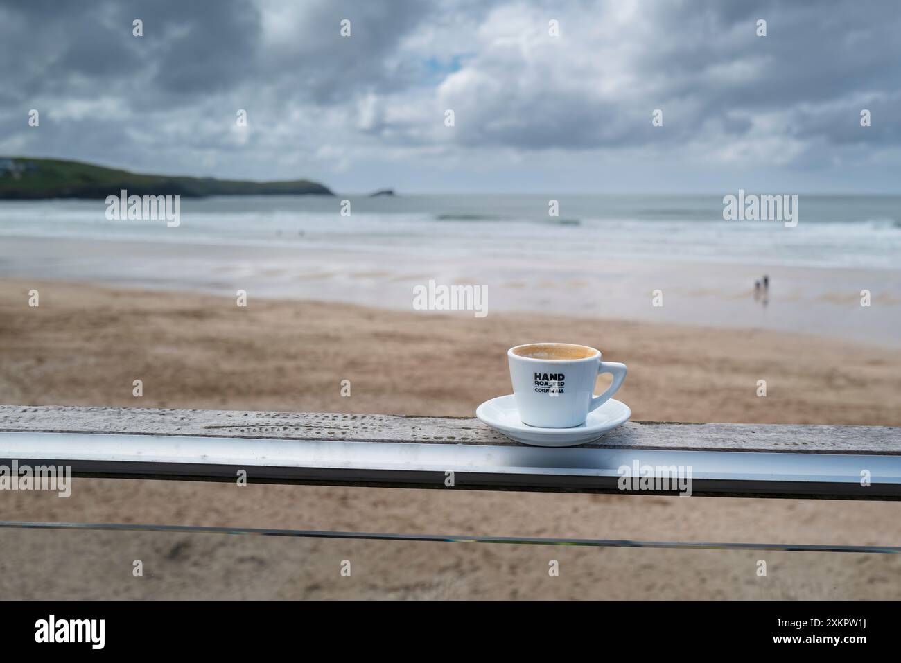 A cup of coffee balanced on a hand rail on the decking area of the ...