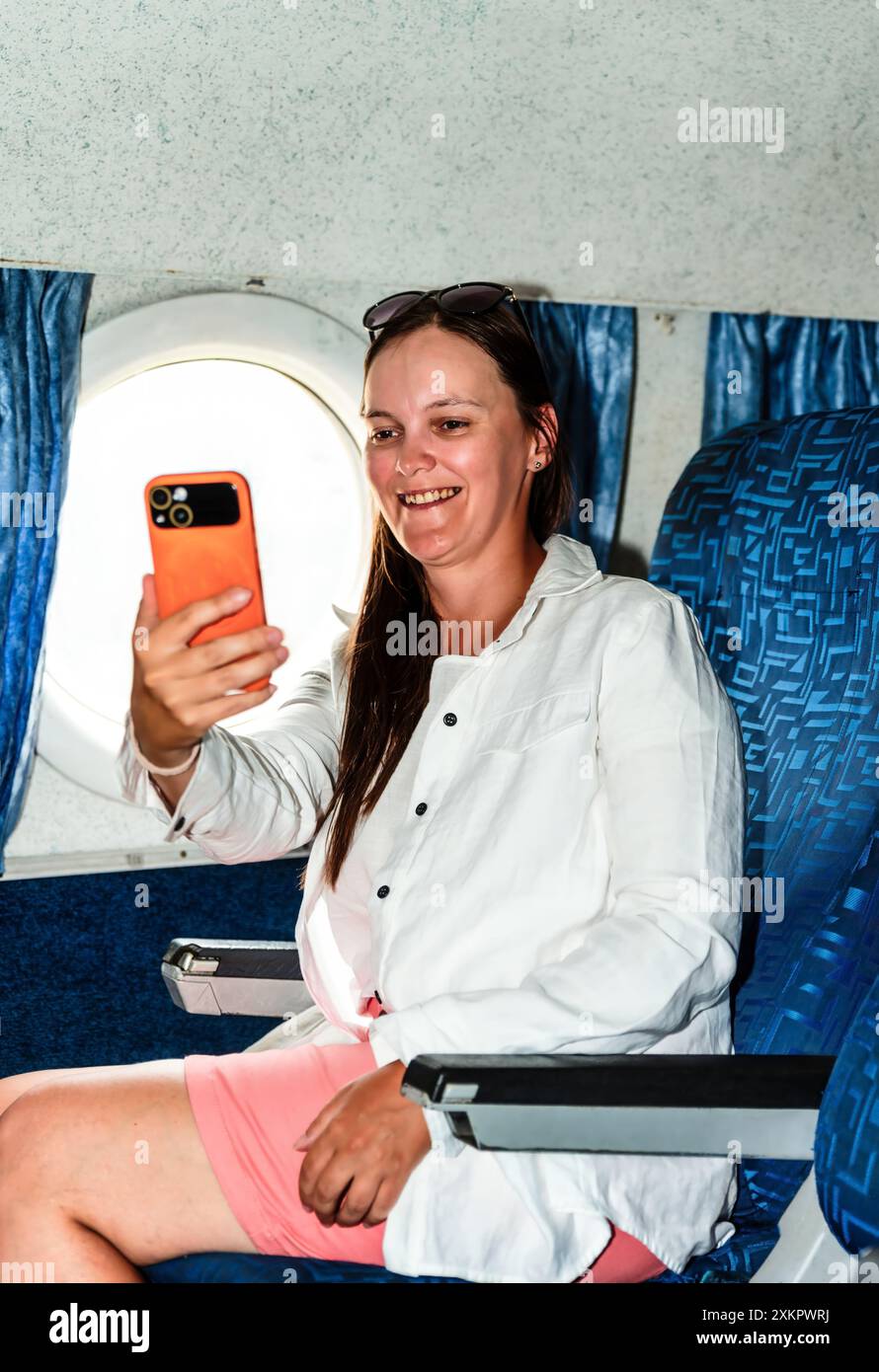 36 years old woman passenger taking a selfie during a flight in the ...
