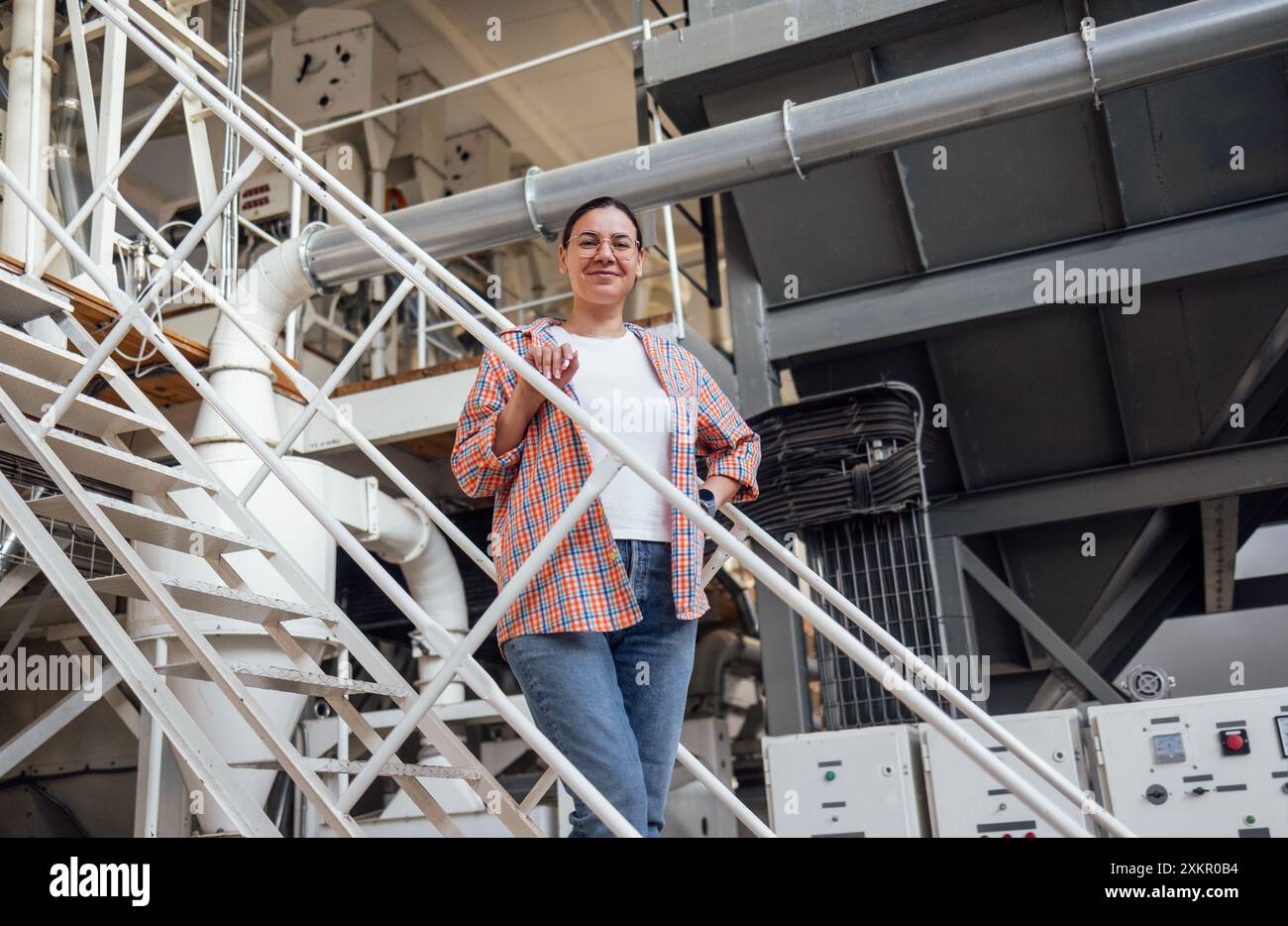 A young smiling woman in casual clothes works at an elevator. An ...