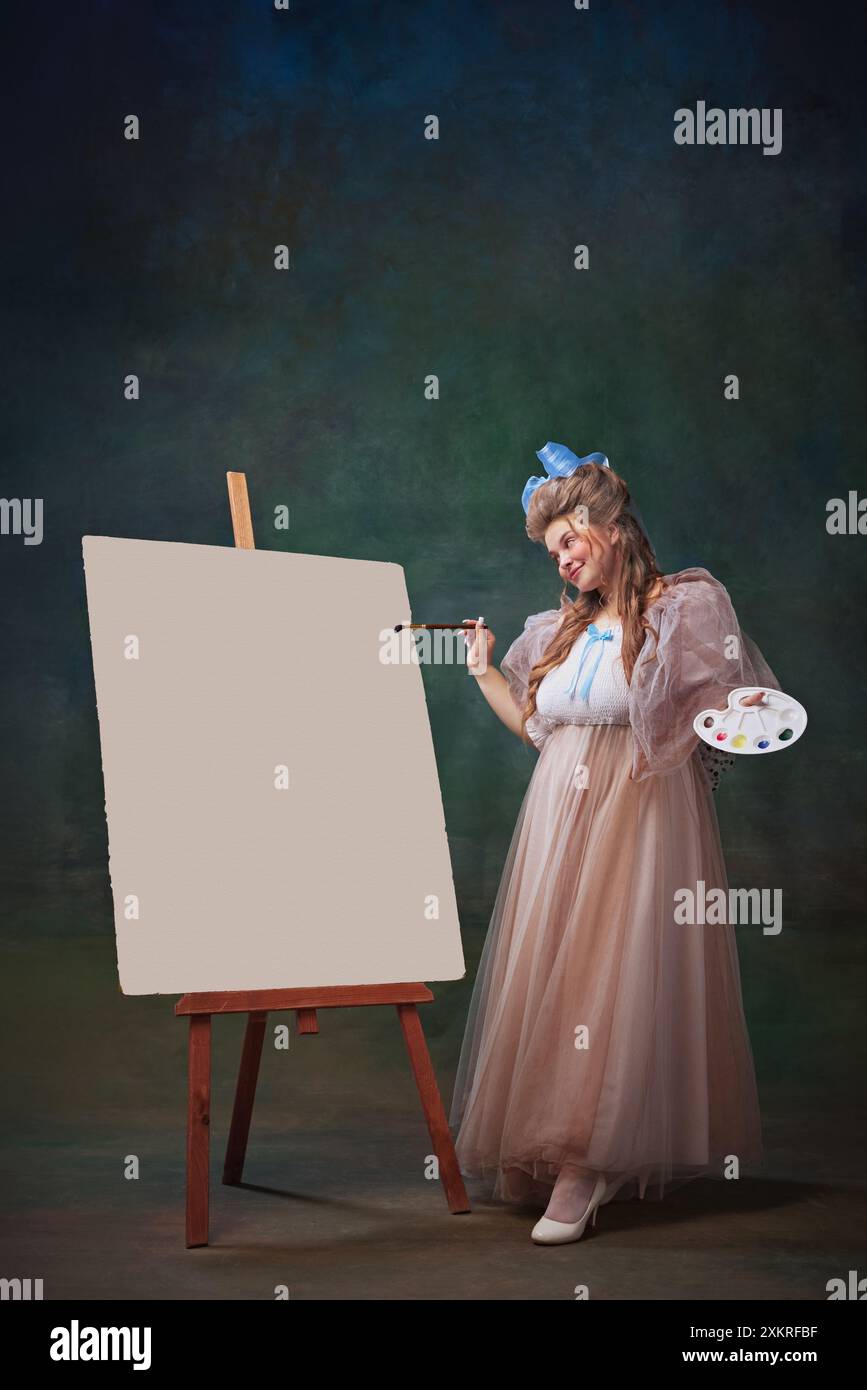 Inspired artist. Young woman in period attire standing with palette ...