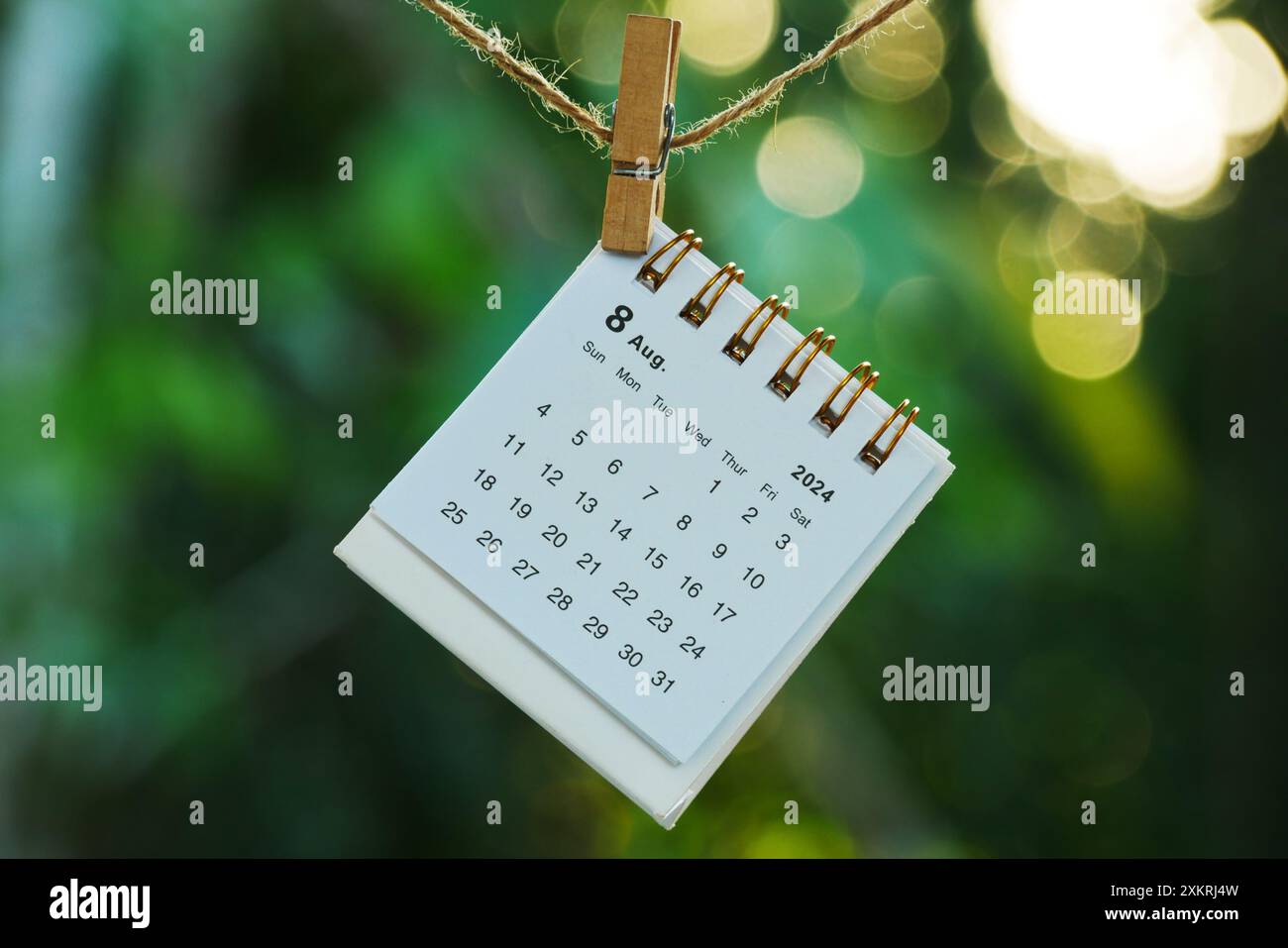 August 2024, August 2024 calendar hanging on a rope with bokeh background Stock Photo - Alamy