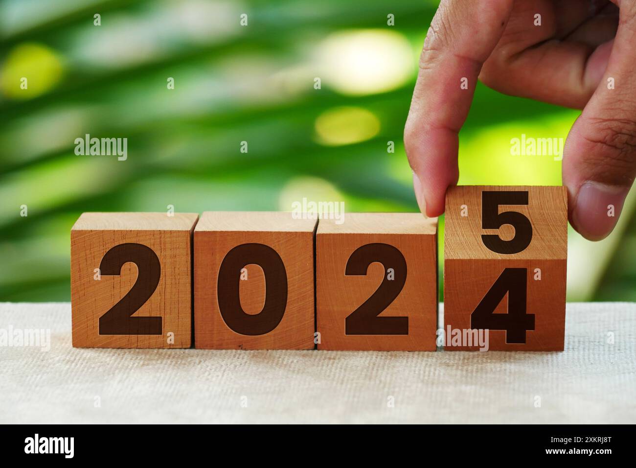 Businessman's hand flips wooden cubes from 2024 to 2025. Concept of ... Businessman's hand flips wooden cubes from 2024 to 2025. Concept of ...