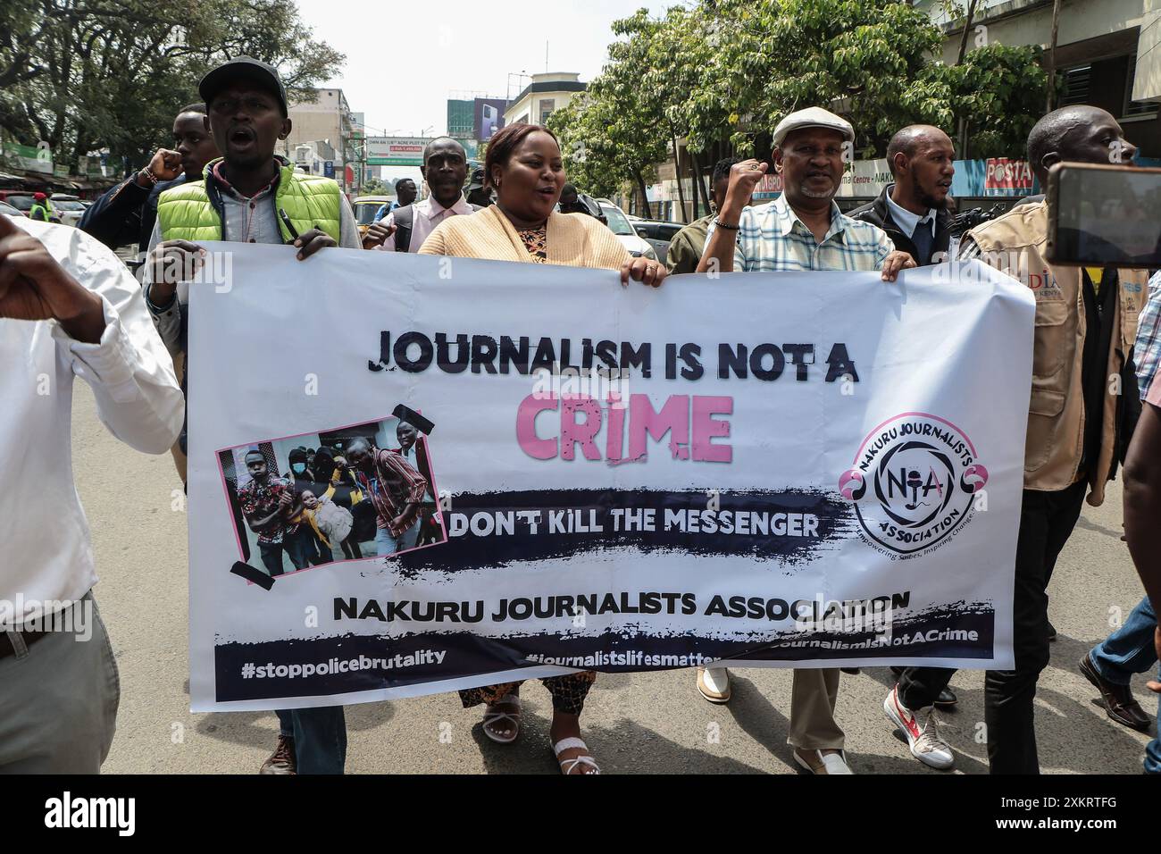 Journalists chant slogans while carrying a banner as they march during ...