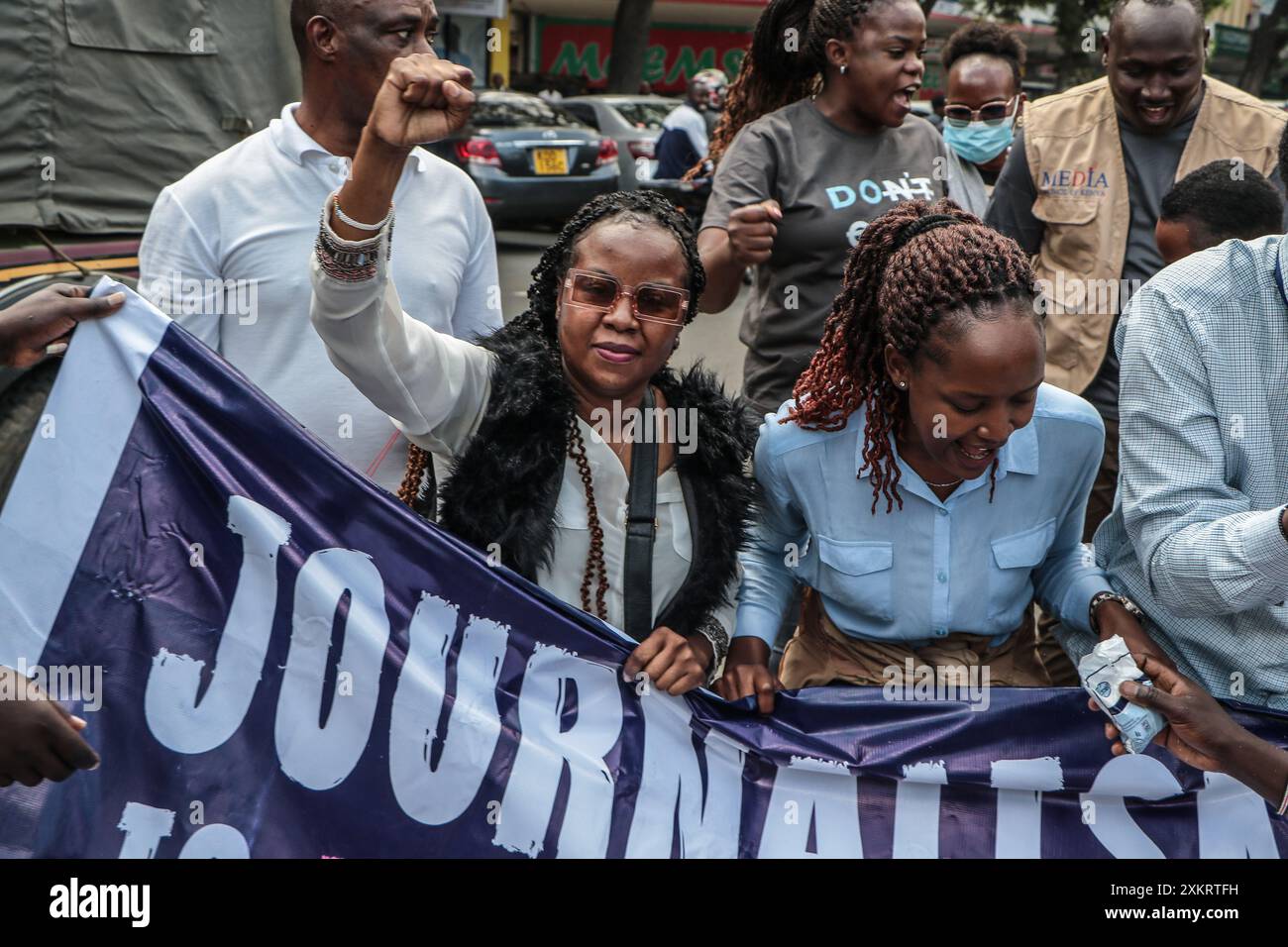 Journalists chant slogans while carrying a banner as they march during ...