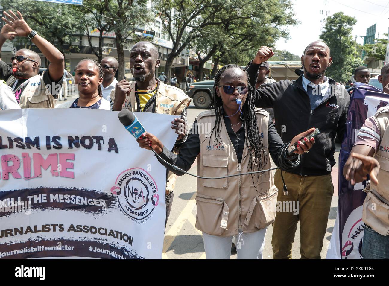 Journalists chant slogans while carrying a banner as they march during ...
